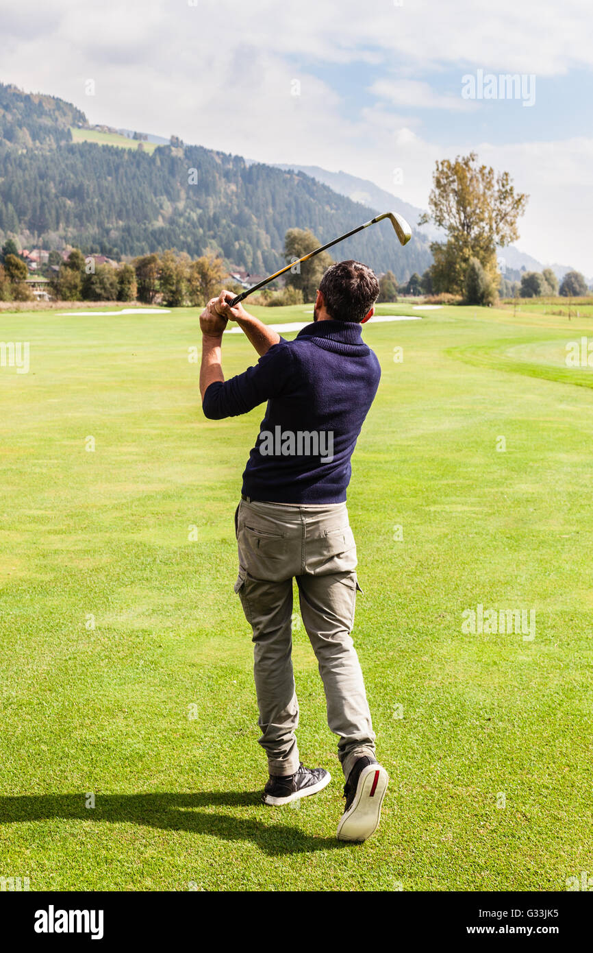 a golf player making a swing on a vibrant beautiful golf course Stock ...