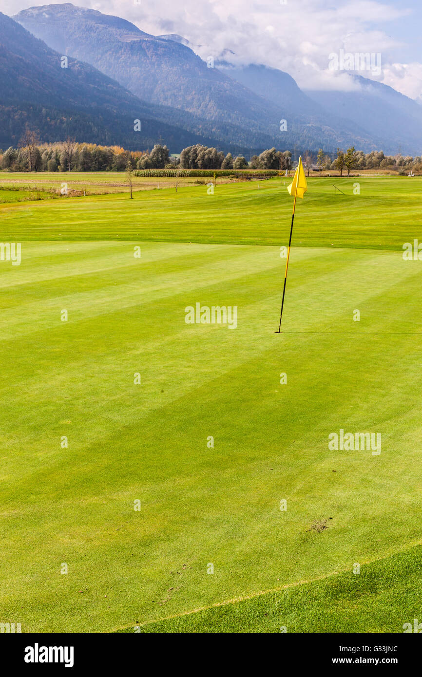 a golf hole with a flag pole in a beautiful golf course Stock Photo - Alamy