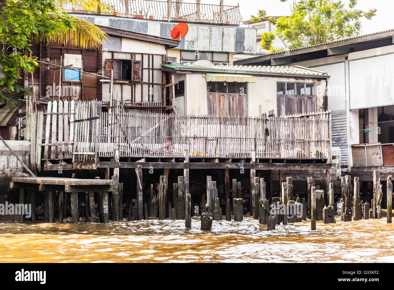 Wooden slums on stilts on the riverside of Chao Praya River in Bangkok ...