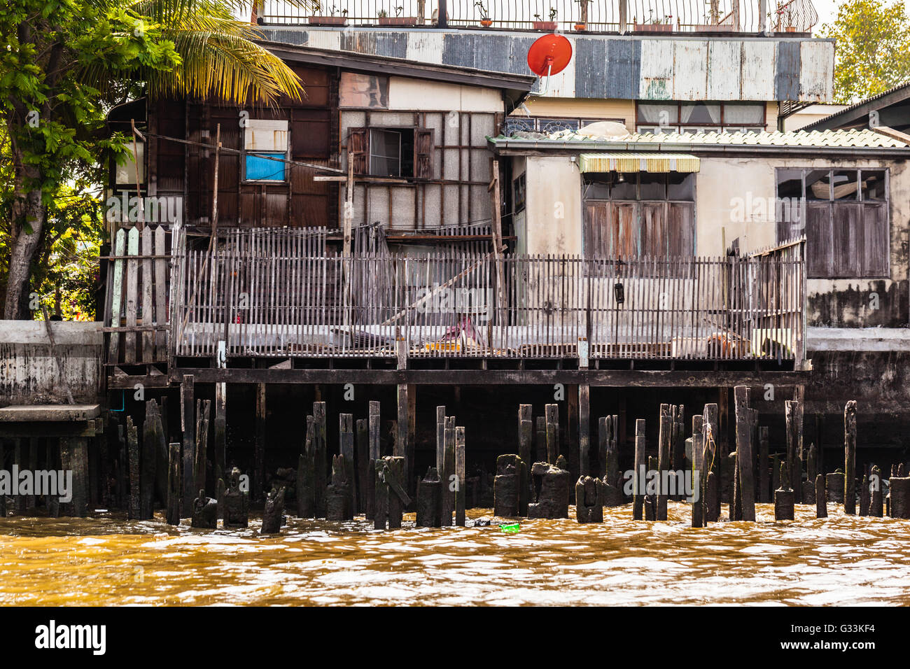 Wooden slums on stilts on the riverside of Chao Praya River in Bangkok ...