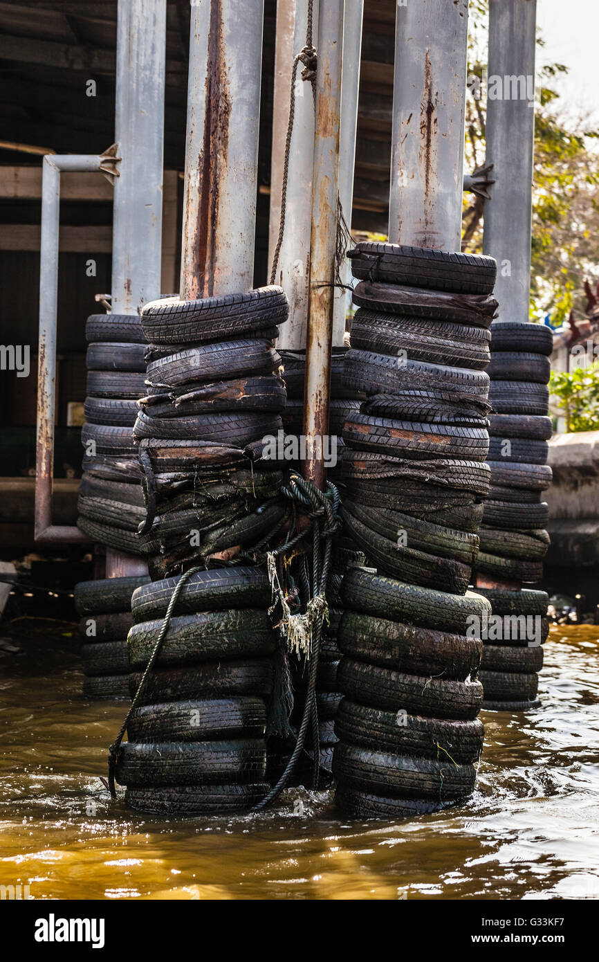 wooden mooring posts covered with old tires bumpers Stock Photo - Alamy