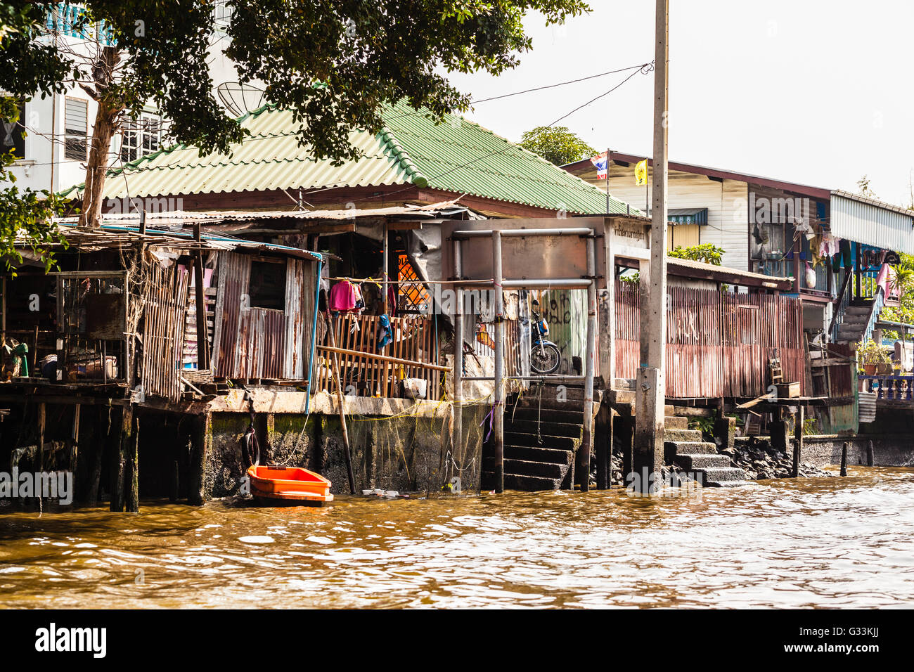 Wooden slums on stilts on the riverside of Chao Praya River in Bangkok ...