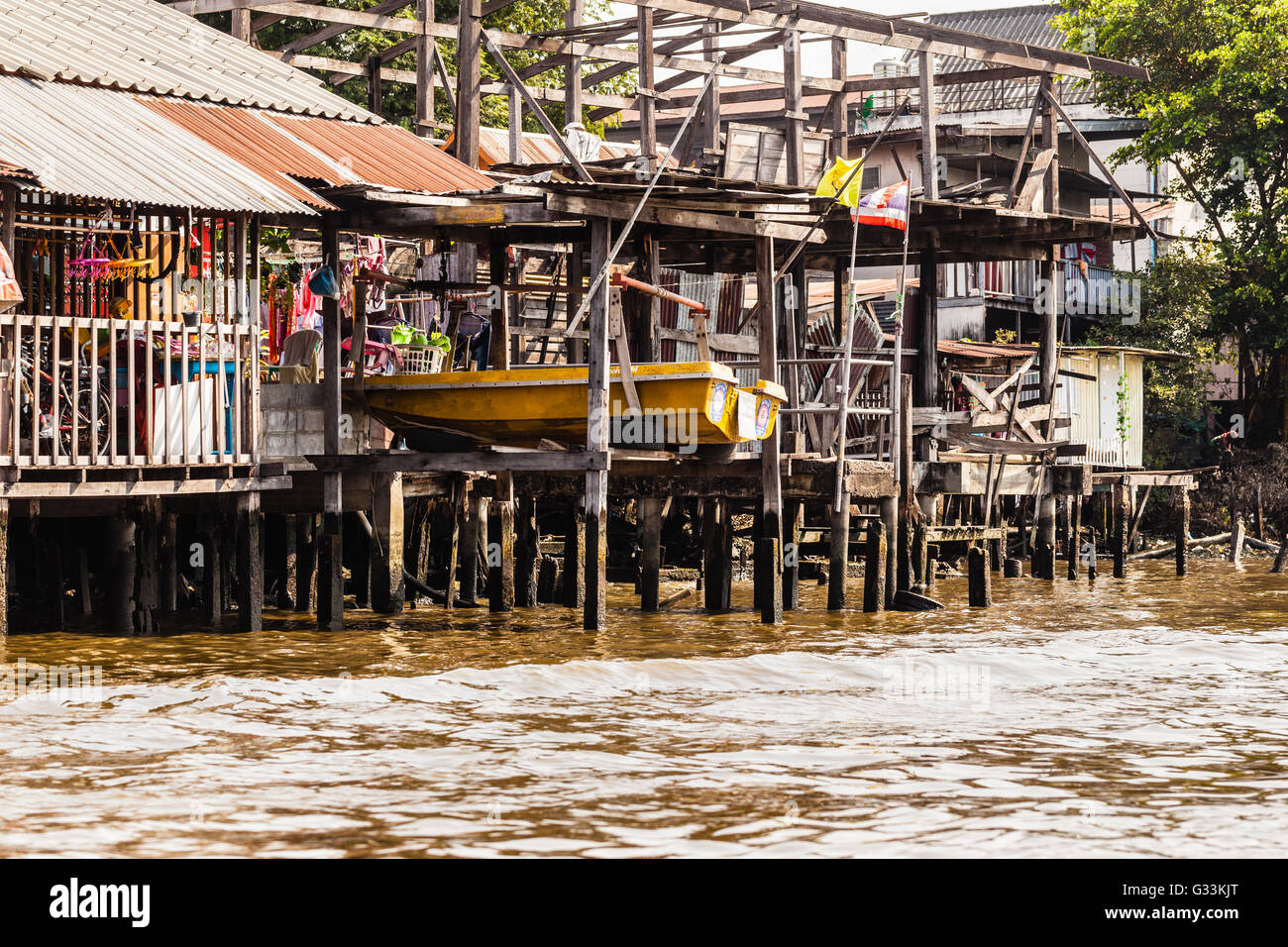 Wooden slums on stilts on the riverside of Chao Praya River in Bangkok ...