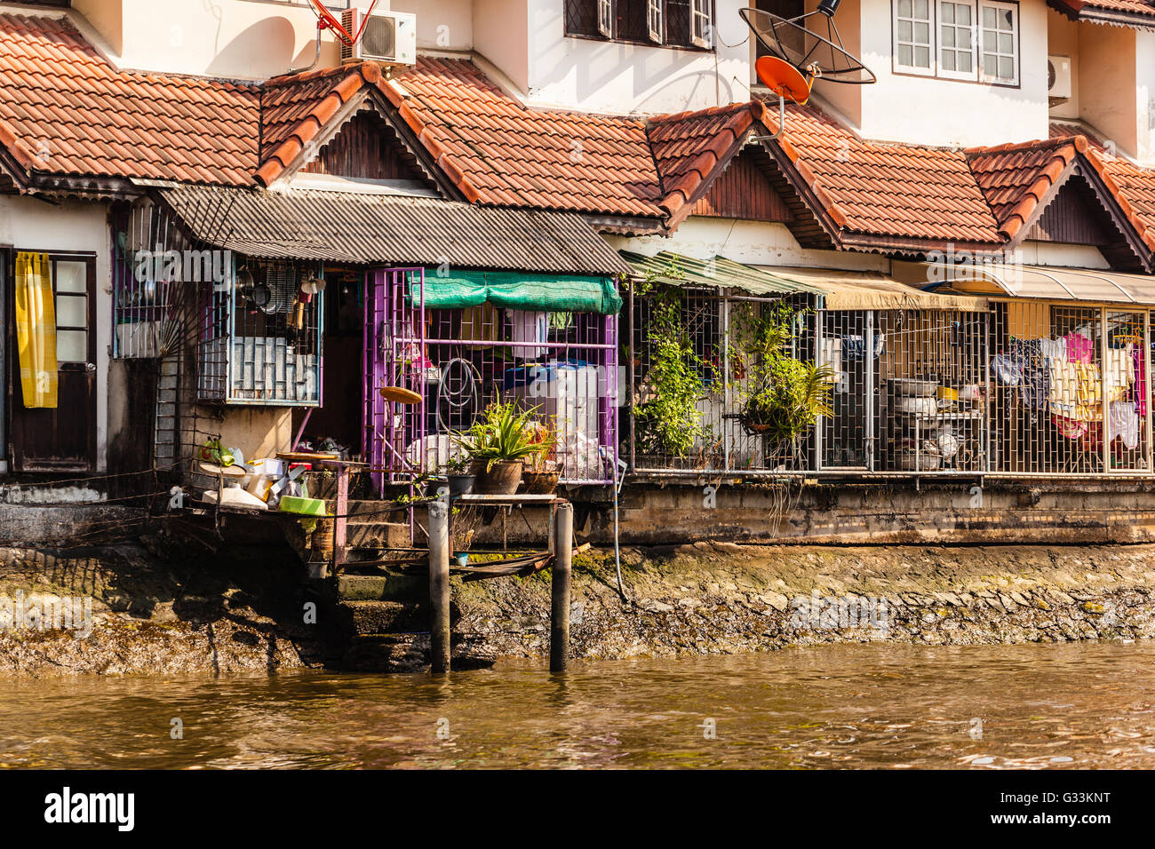 Wooden slums on stilts on the riverside of Chao Praya River in Bangkok ...