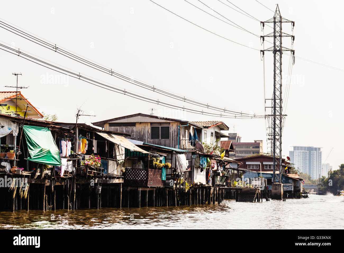 Wooden slums on stilts on the riverside of Chao Praya River in Bangkok ...