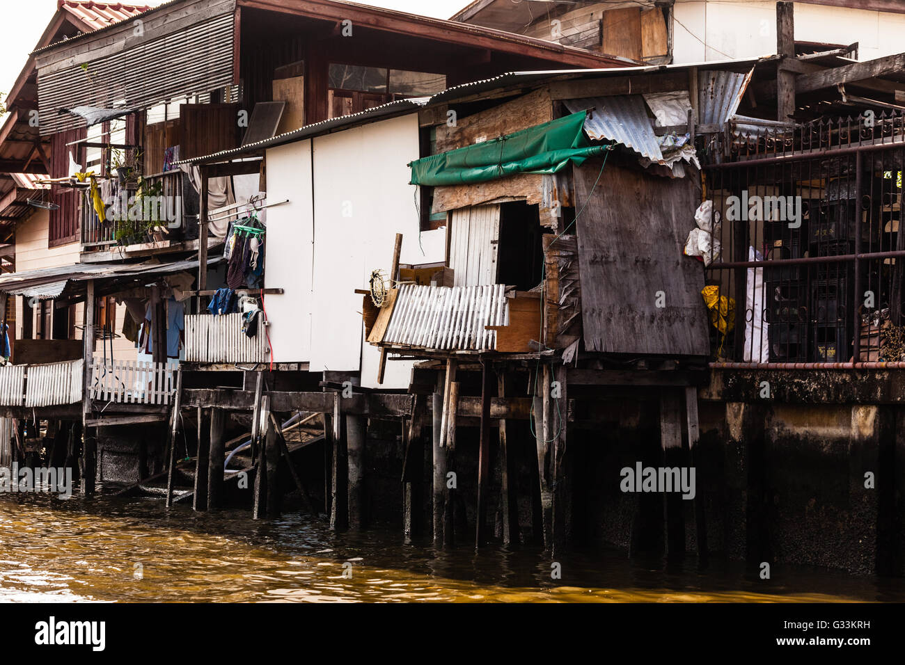 Wooden slums on stilts on the riverside of Chao Praya River in Bangkok ...