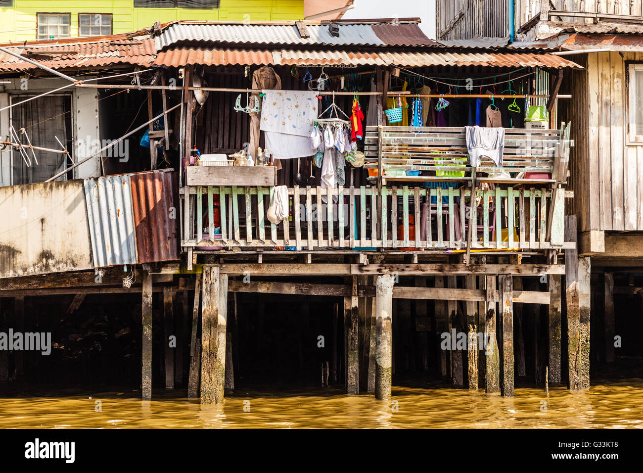Wooden slums on stilts on the riverside of Chao Praya River in Bangkok ...