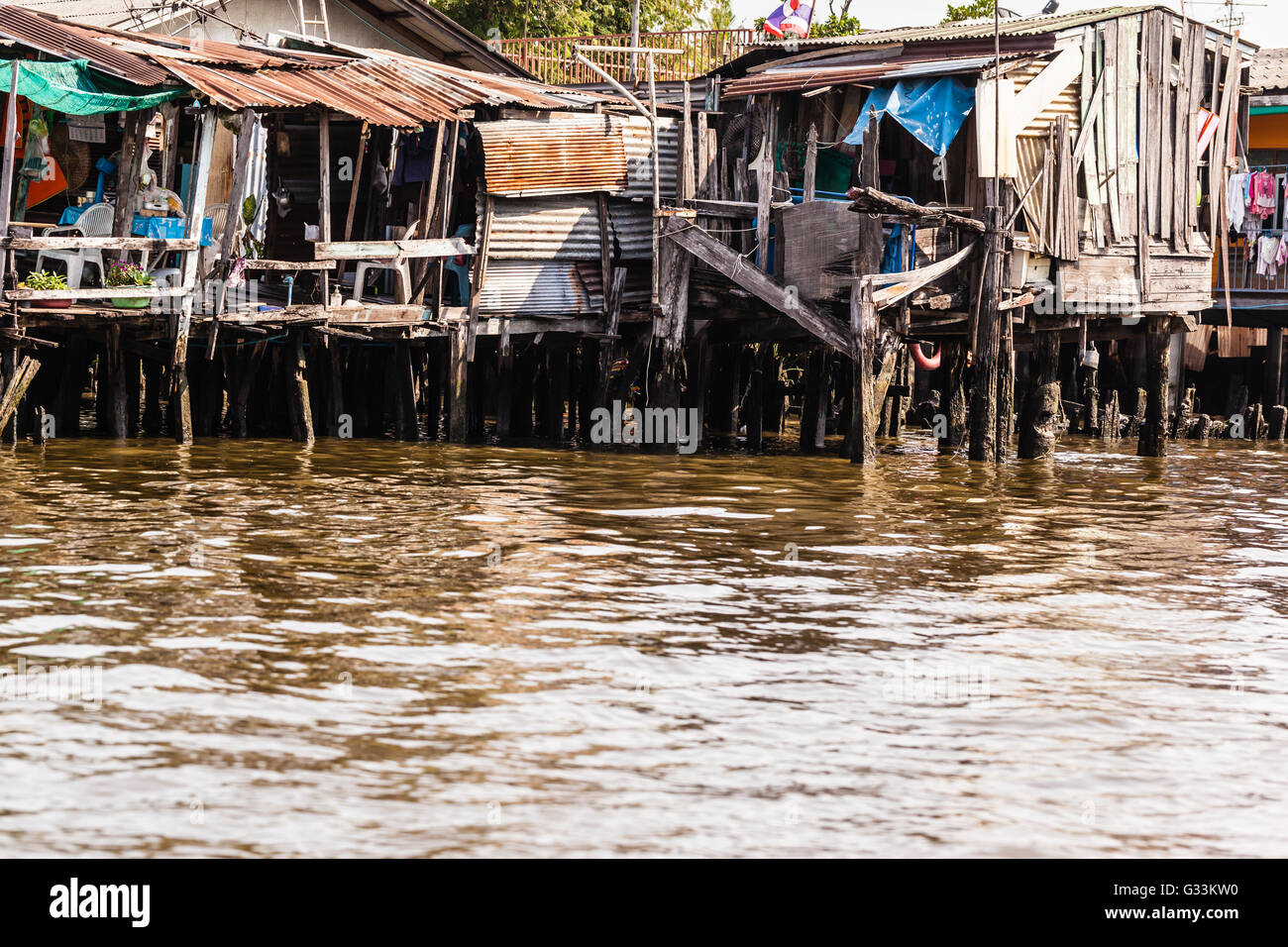 Wooden slums on stilts on the riverside of Chao Praya River in Bangkok ...