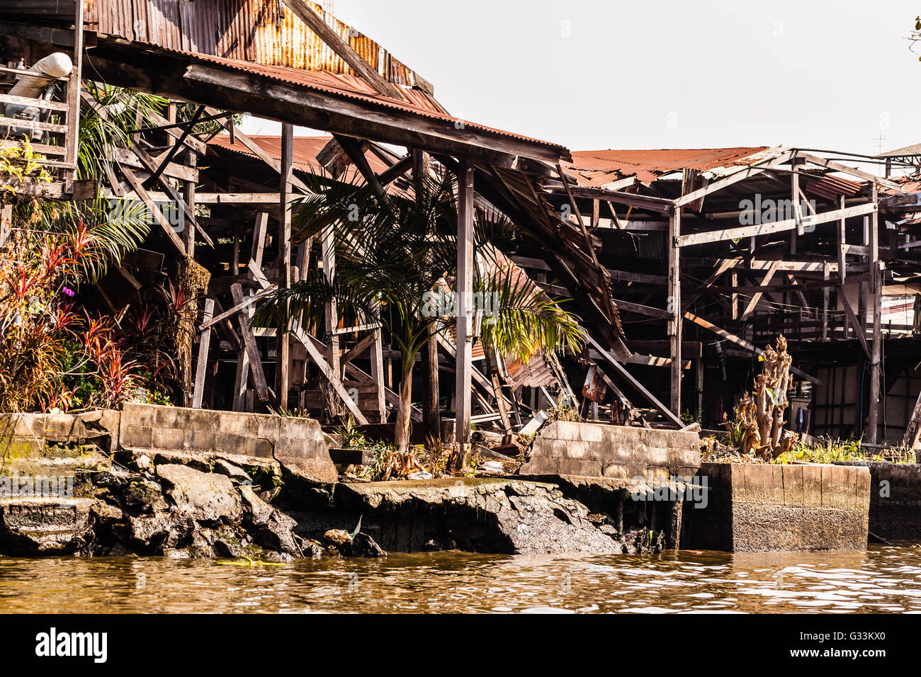 Wooden slums on stilts on the riverside of Chao Praya River in Bangkok ...