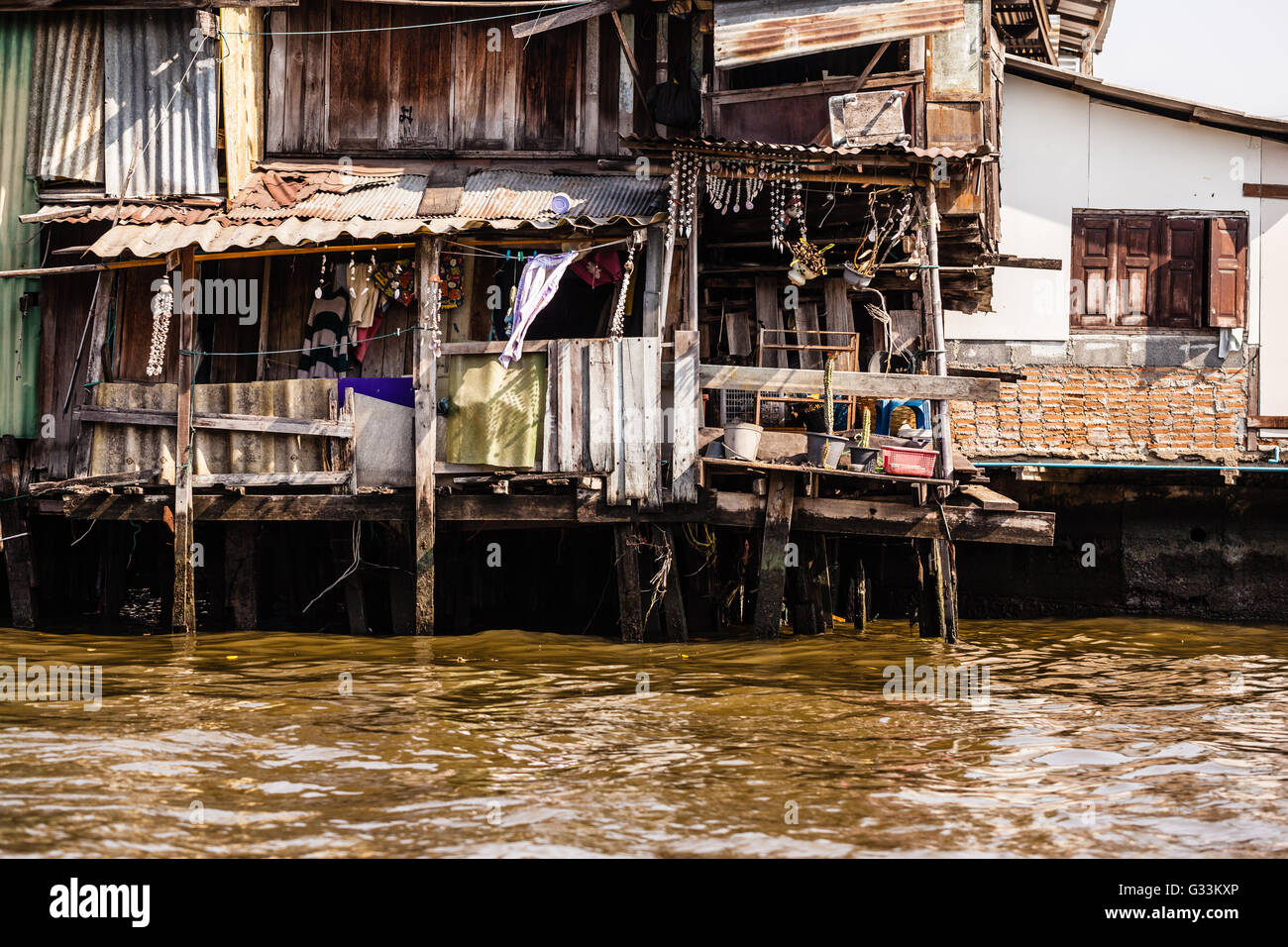 Wooden slums on stilts on the riverside of Chao Praya River in Bangkok ...
