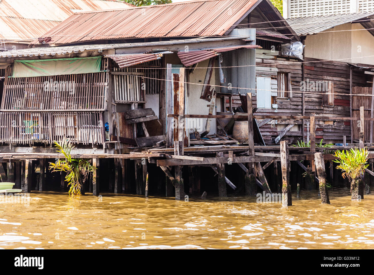 Wooden slums on stilts on the riverside of Chao Praya River in Bangkok ...