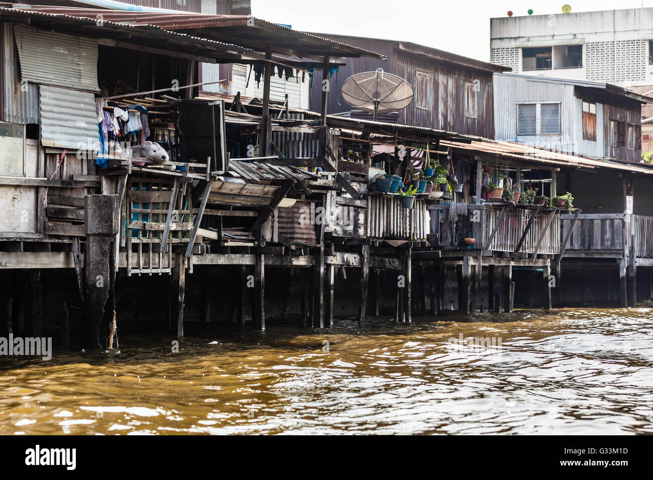 Wooden slums on stilts on the riverside of Chao Praya River in Bangkok ...