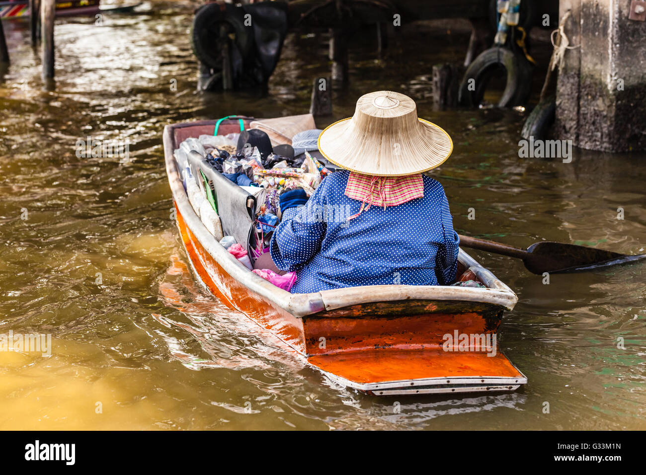 a thai hawker with the typical hat floating with her boat on the Chao ...
