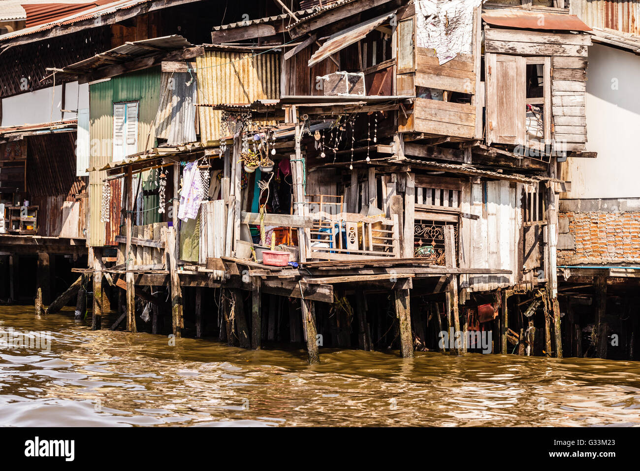 Wooden slums on stilts on the riverside of Chao Praya River in Bangkok ...