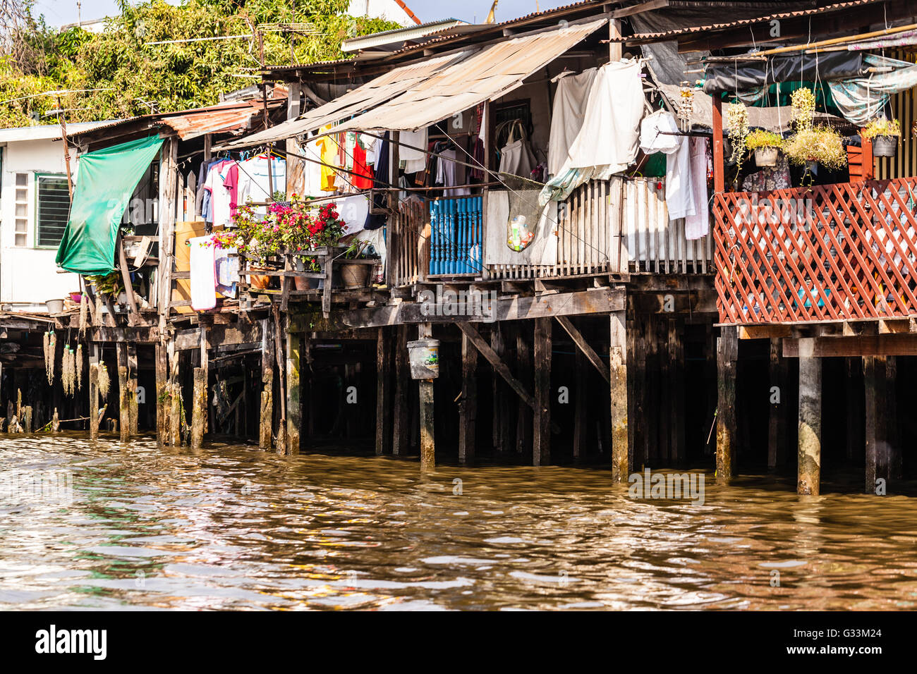 Wooden slums on stilts on the riverside of Chao Praya River in Bangkok ...