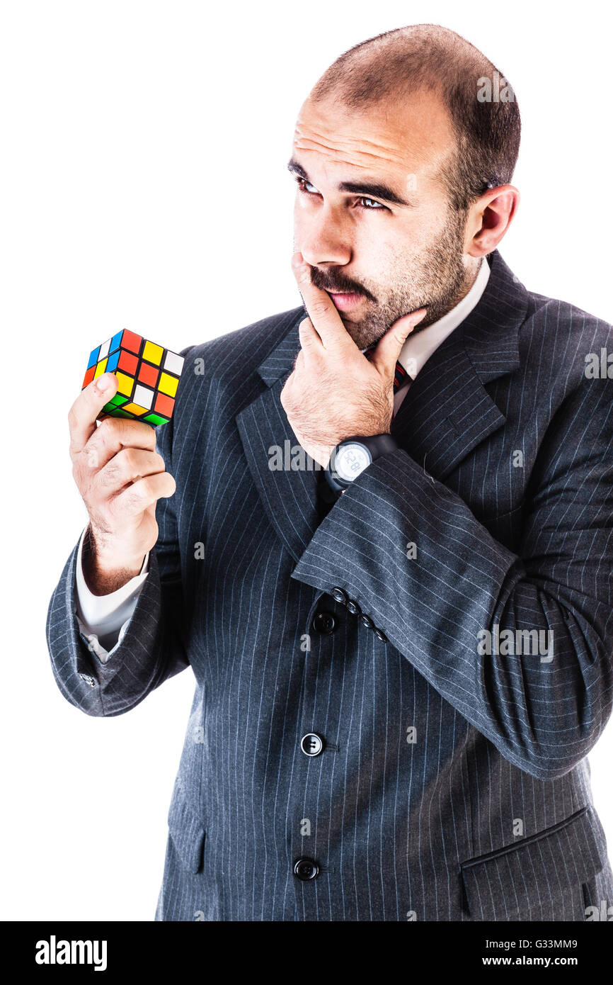 portrait of a businessman trying to solve a cube puzzle isolated over a ...