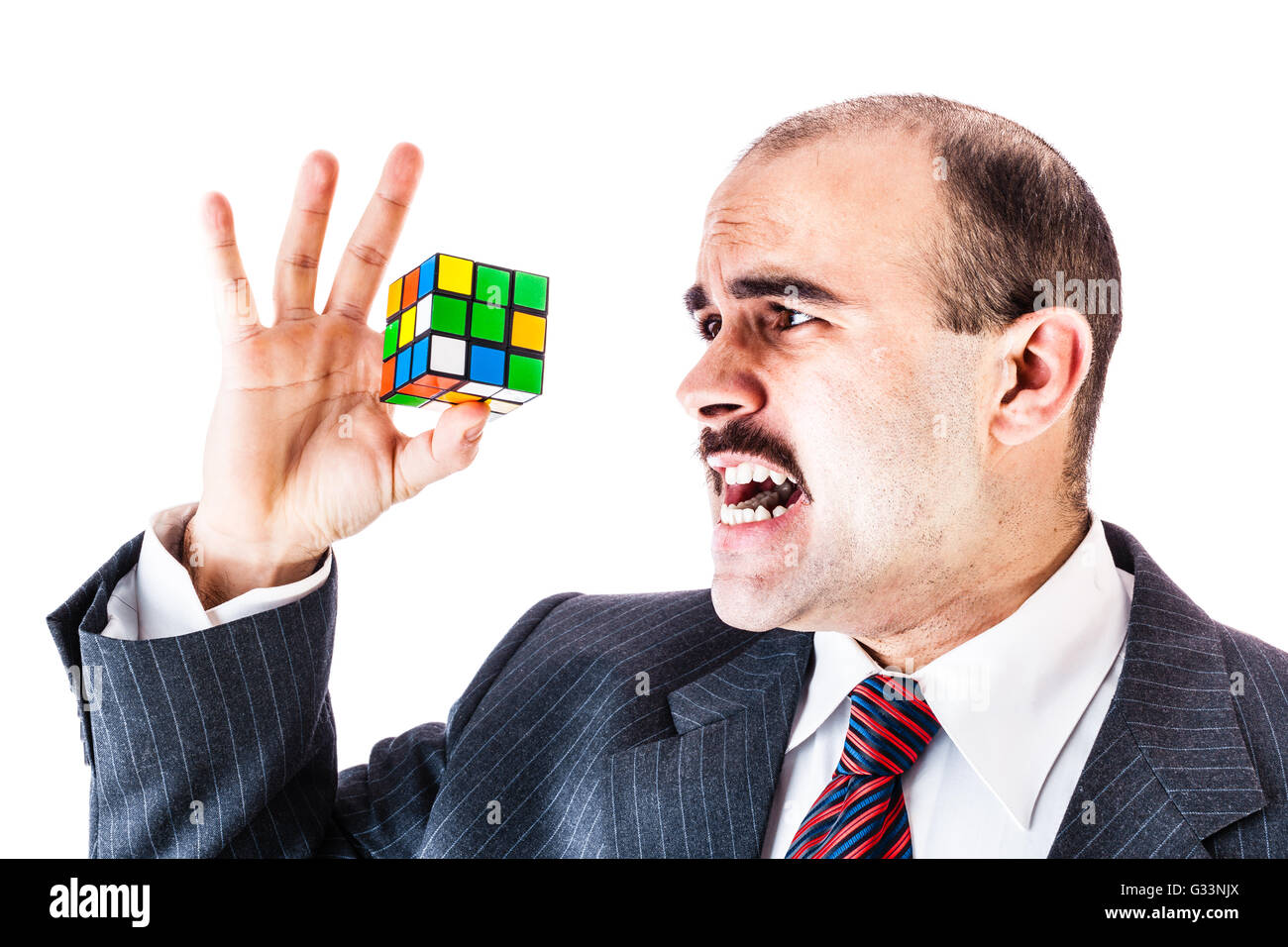 portrait of a businessman trying to solve a cube puzzle isolated over a ...