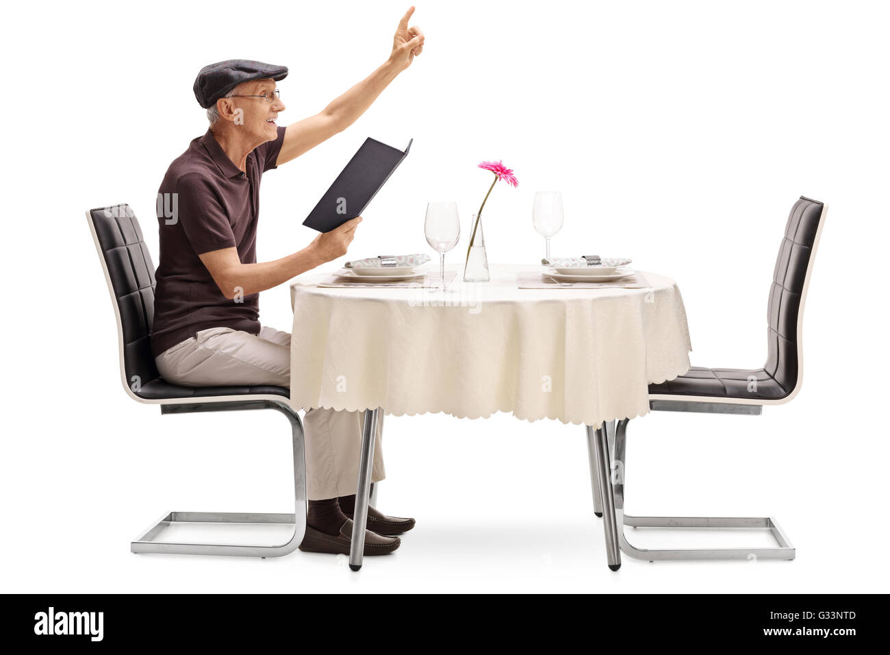 Senior gentleman sitting at a restaurant table and calling the waiter ...