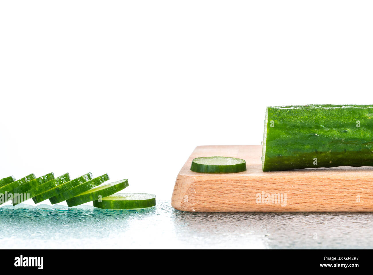 Fresh Cucumber slices on wood cutting board on white background Stock ...