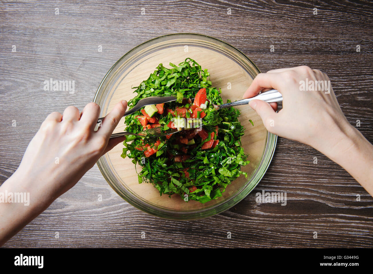 Cooking salad. Young woman cooking vegetable salad at home Stock Photo ...