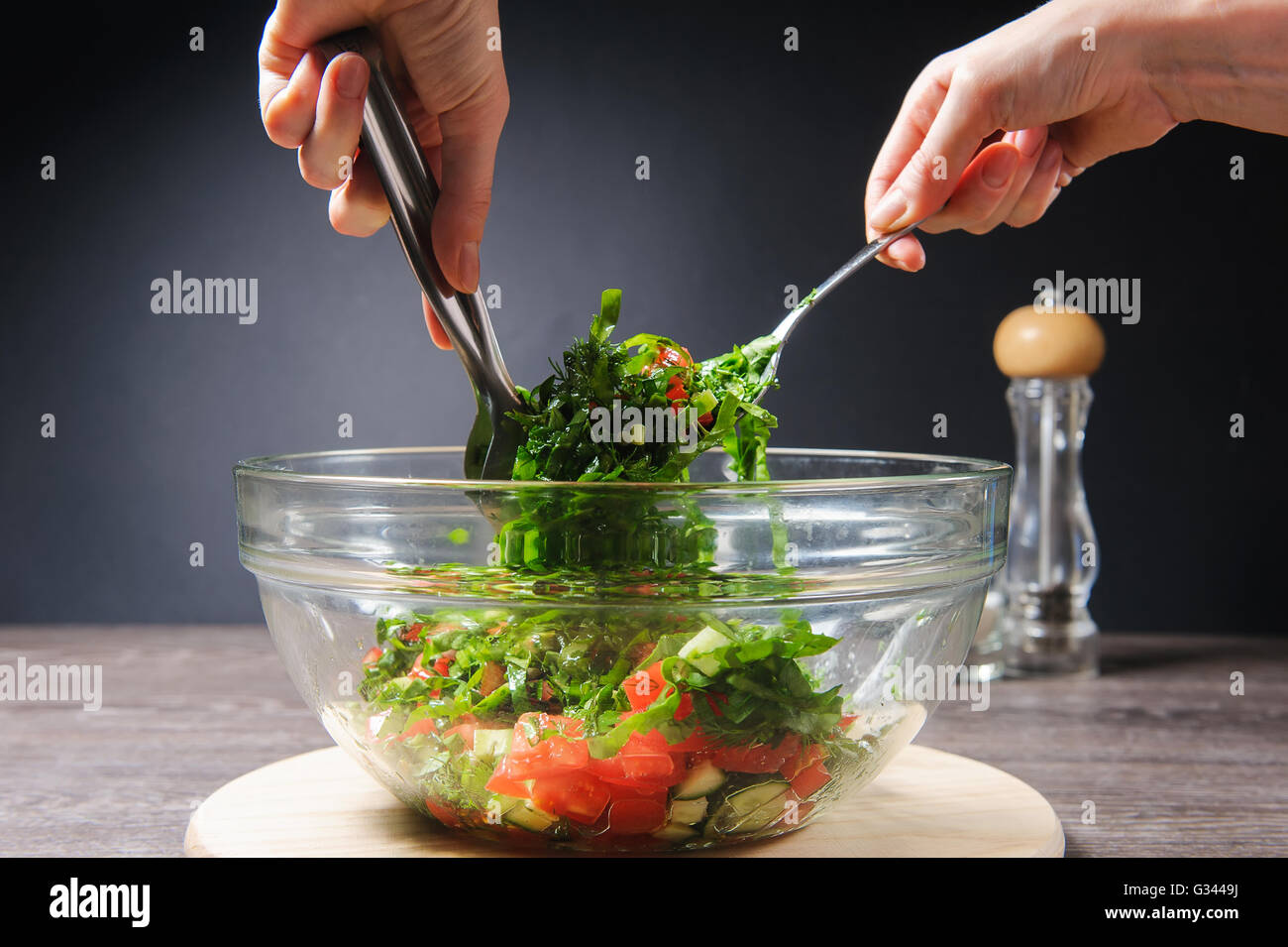 Cooking salad. Young woman cooking vegetable salad at home Stock Photo ...