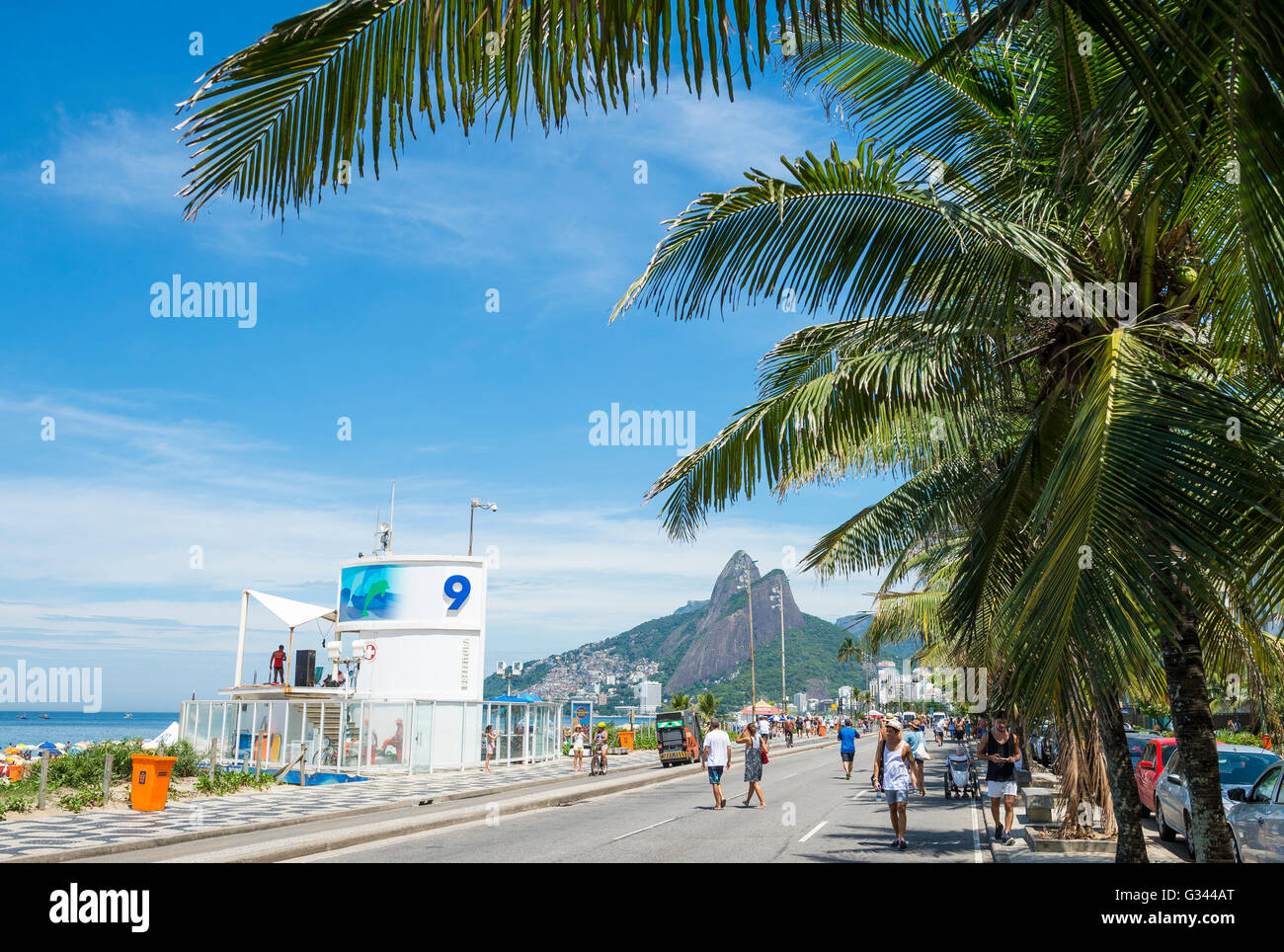 RIO DE JANEIRO - FEBRUARY 28, 2016: Beachgoers stroll with active ...