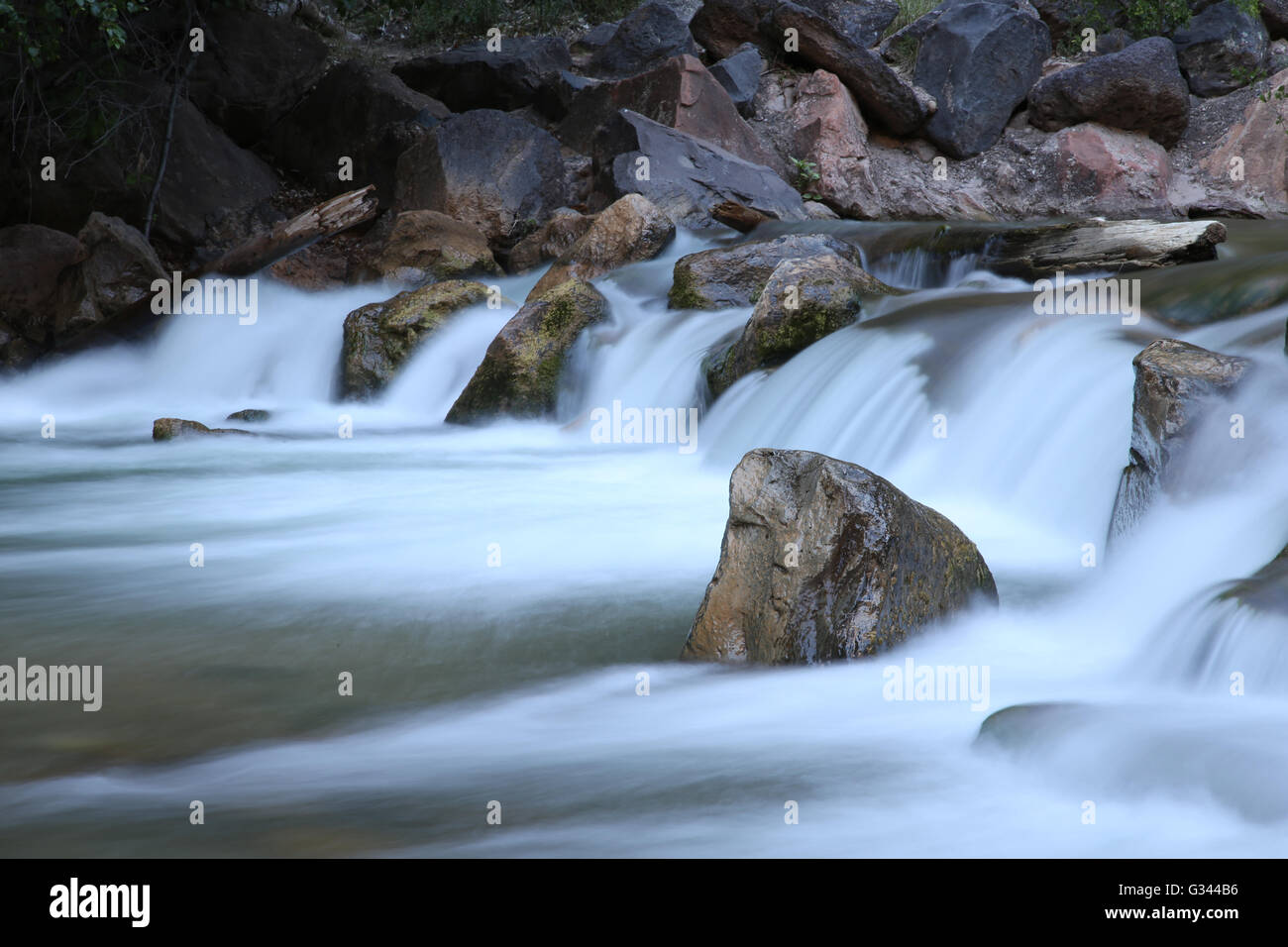 Flowing spring water with rocks Stock Photo - Alamy