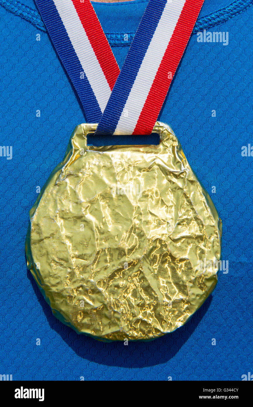 Gold medal hanging from USA colors red, white, and blue ribbon on blue ...