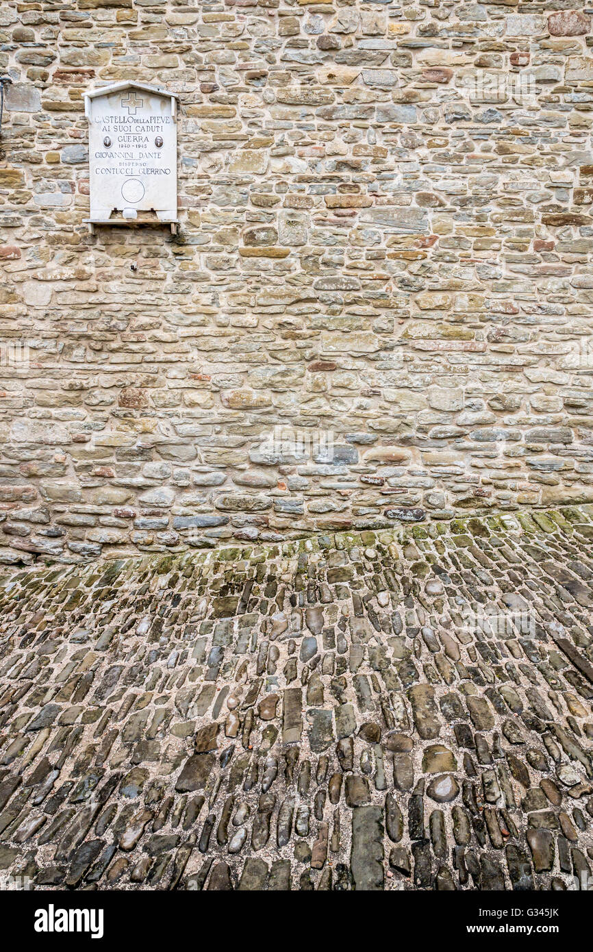 Marble memorial piece hanging from stone wall and cobblestone street ...