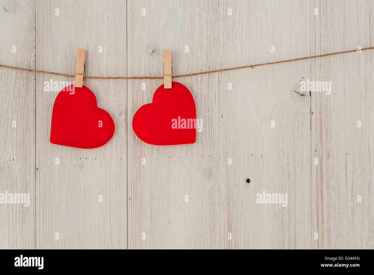 Heart shape hanging on the clothesline. On old wood background Stock ...