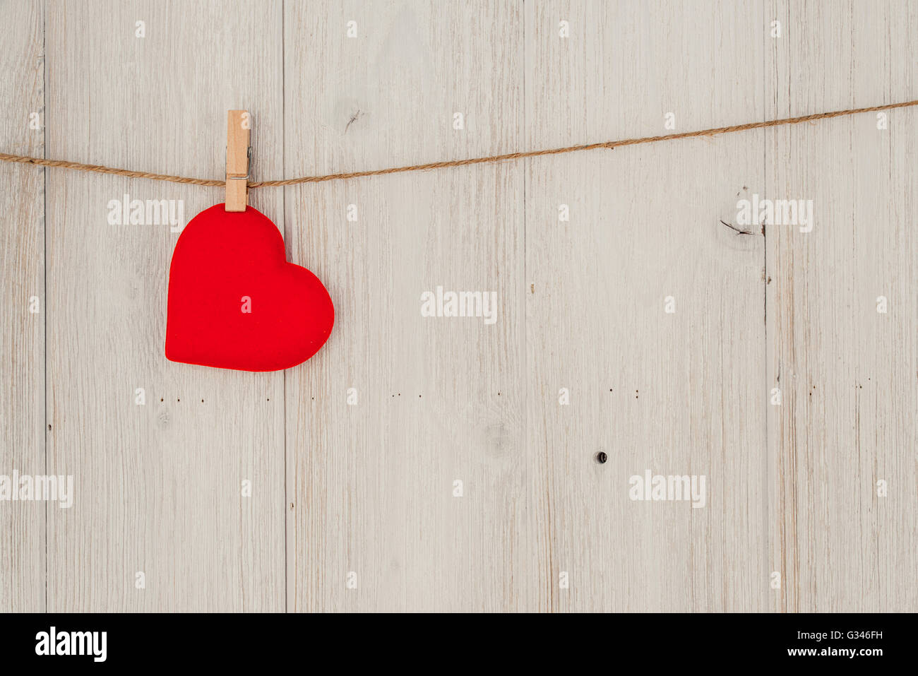 Heart shape hanging on the clothesline. On old wood background Stock ...