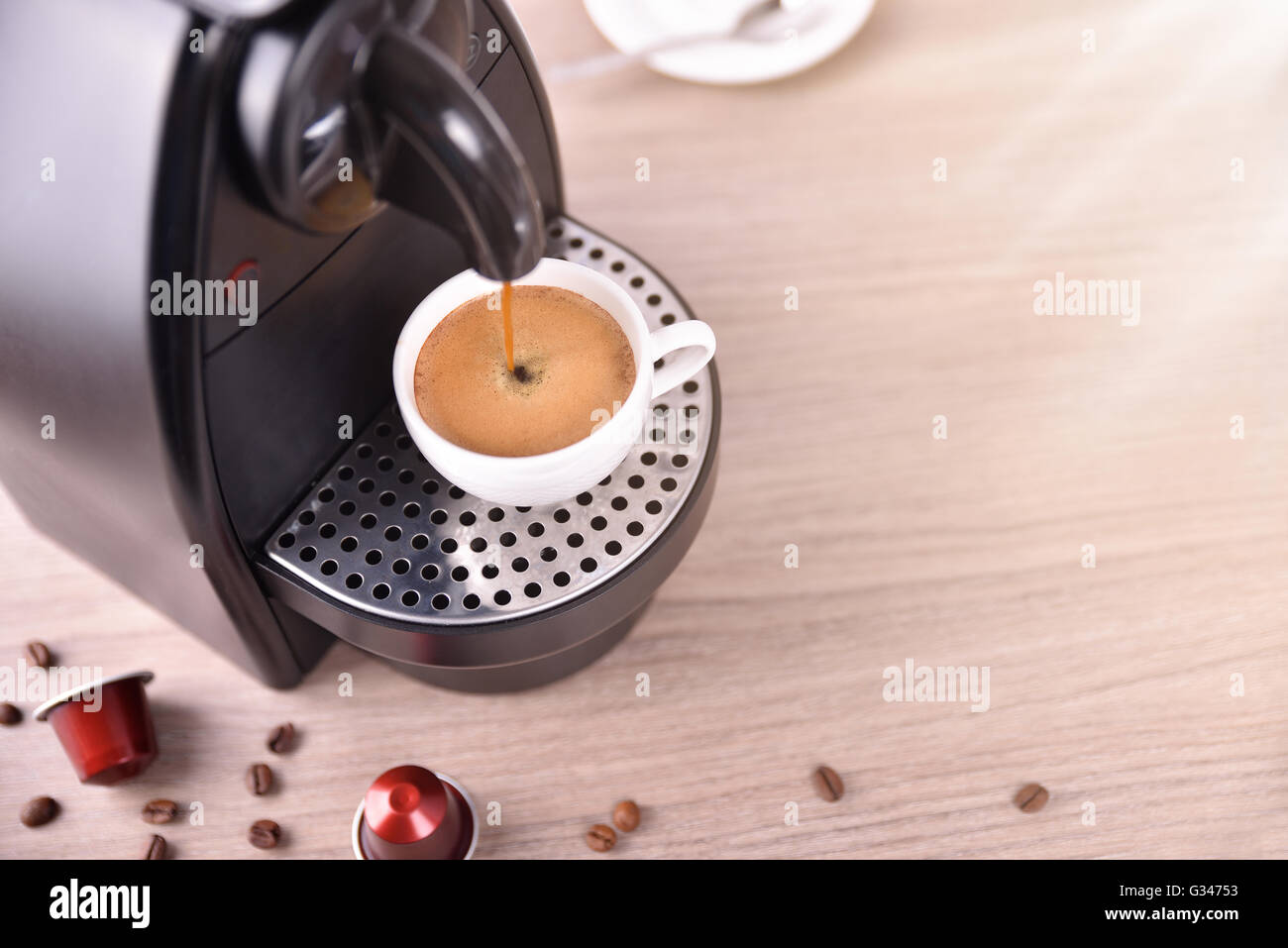 Espresso machine making coffee with capsules background on wood table ...