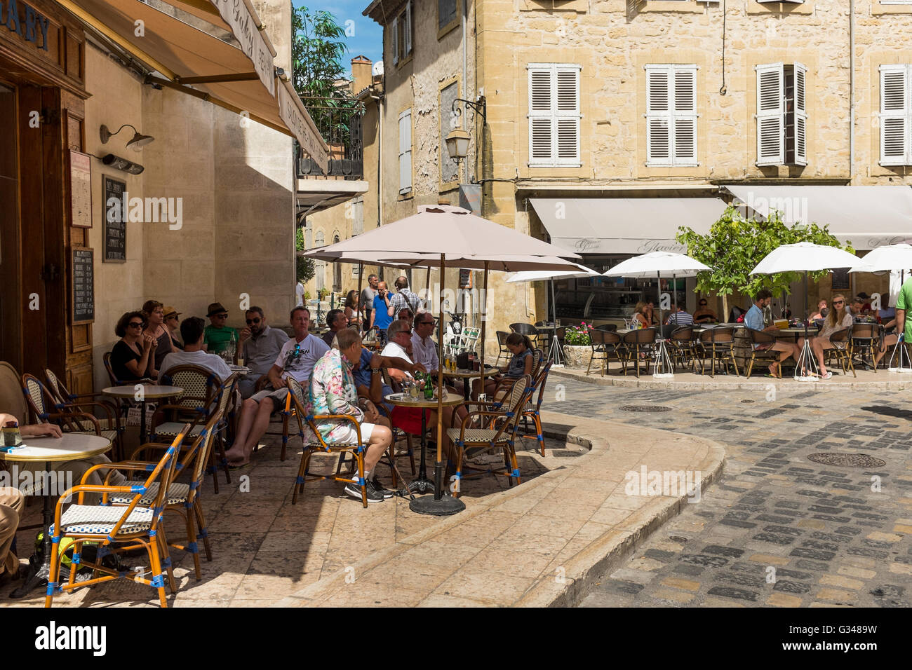 Tourists relaxing at a pavement cafe, Lourmarin, Luberon, Vaucluse ...