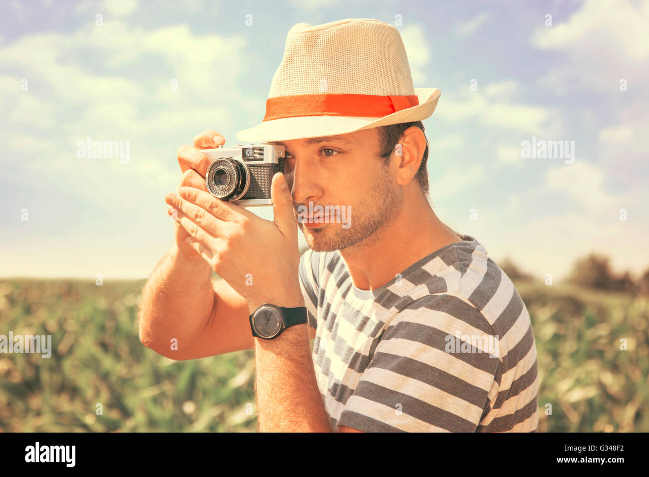 Man taking photo with retro camera Stock Photo - Alamy