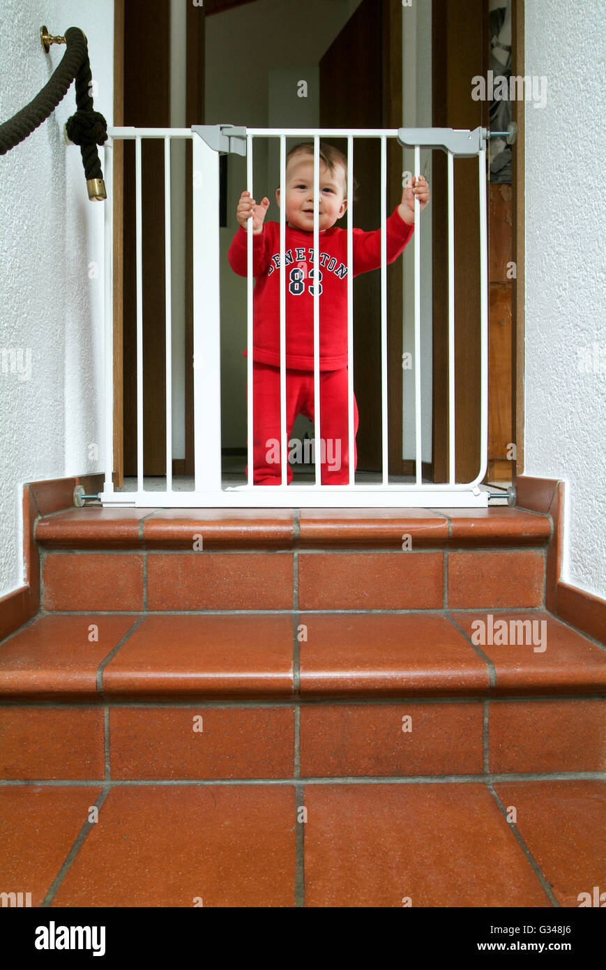 Nine month old baby male behind the cage for the stairs Stock Photo - Alamy