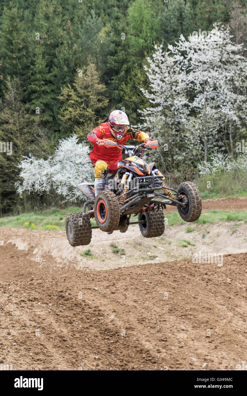 Quad rider in red is jumping Stock Photo - Alamy
