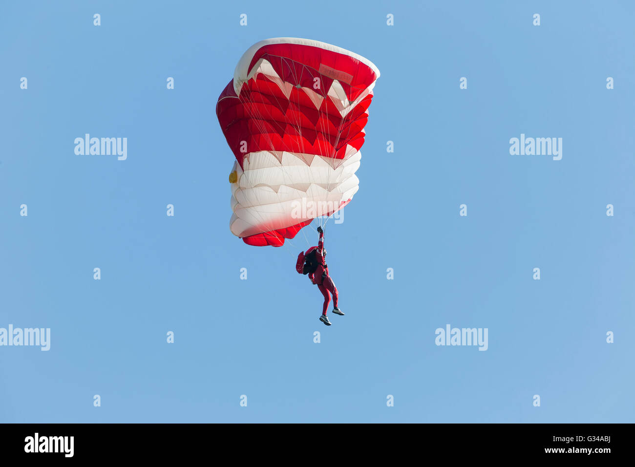 Parachutist with red parachute on a blue sky background Stock Photo - Alamy