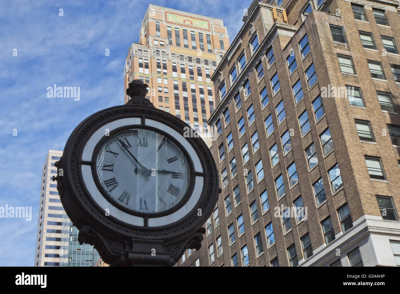 Street clock on the street in Manhattan. Skyscrapers and blue sky in ...