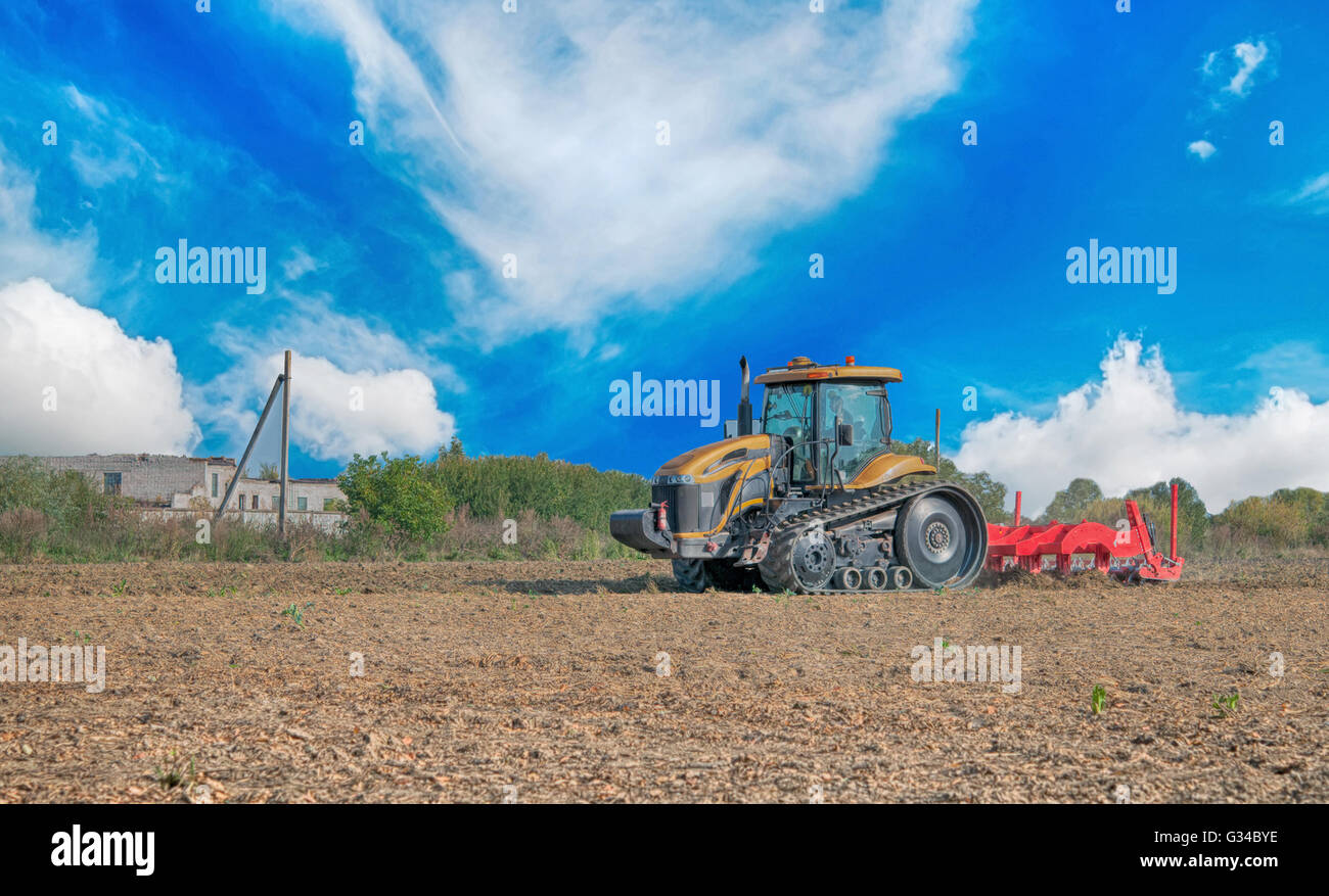 yellow tractor in spring on field Stock Photo - Alamy