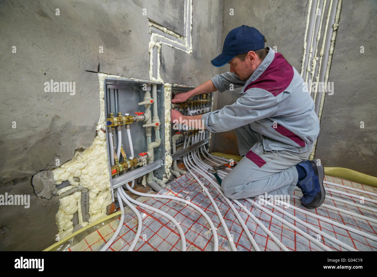 pipefitter installing system of heating Stock Photo - Alamy
