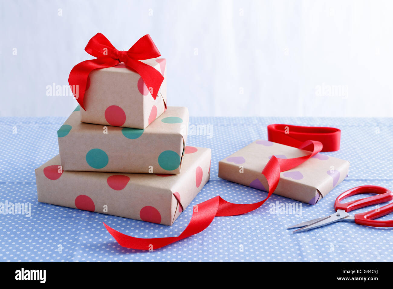 Presents for birthday with wrapped boxes and red ribbon on table Stock ...