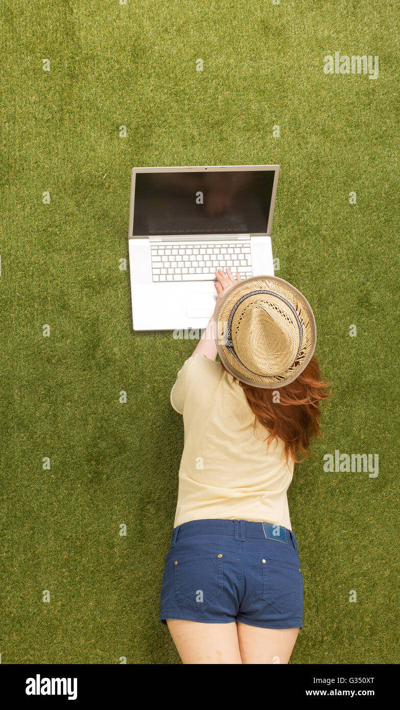 Woman on grass with laptop computer Stock Photo - Alamy