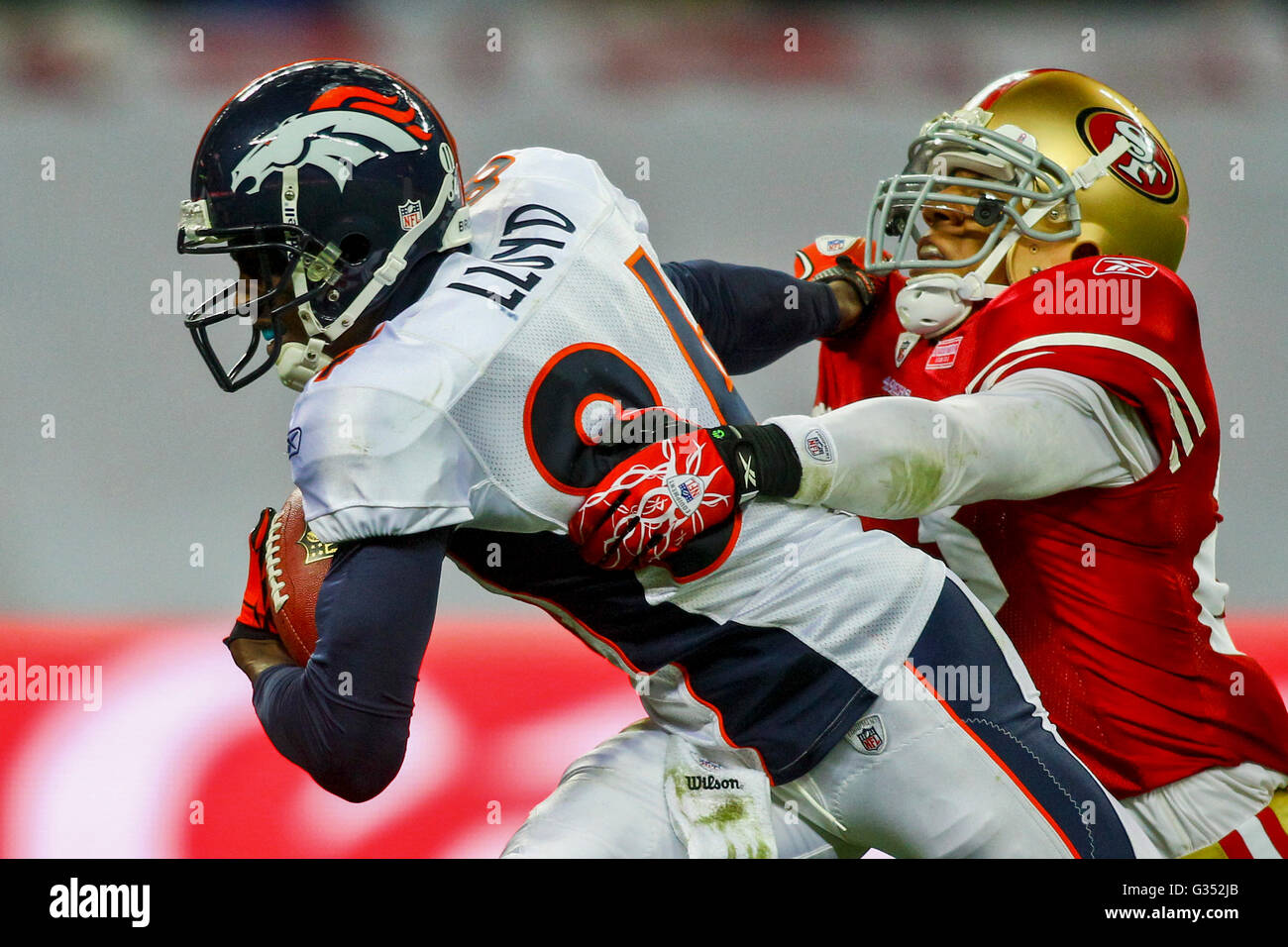WR Brandon Lloyd, #84 Broncos, and SS Taylor Mays, #23 49ers, fight for ...