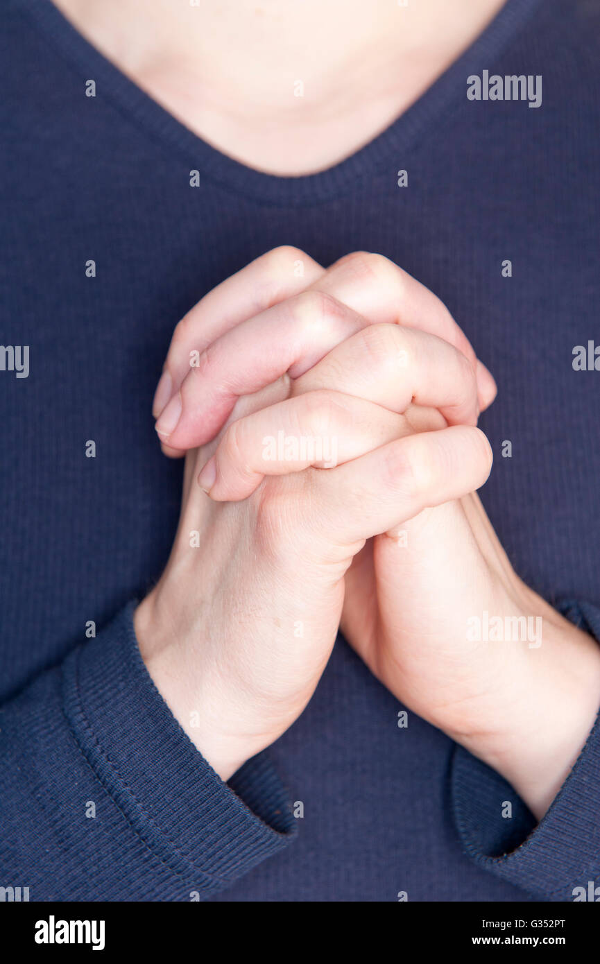 Woman praying with her hands clasped Stock Photo - Alamy