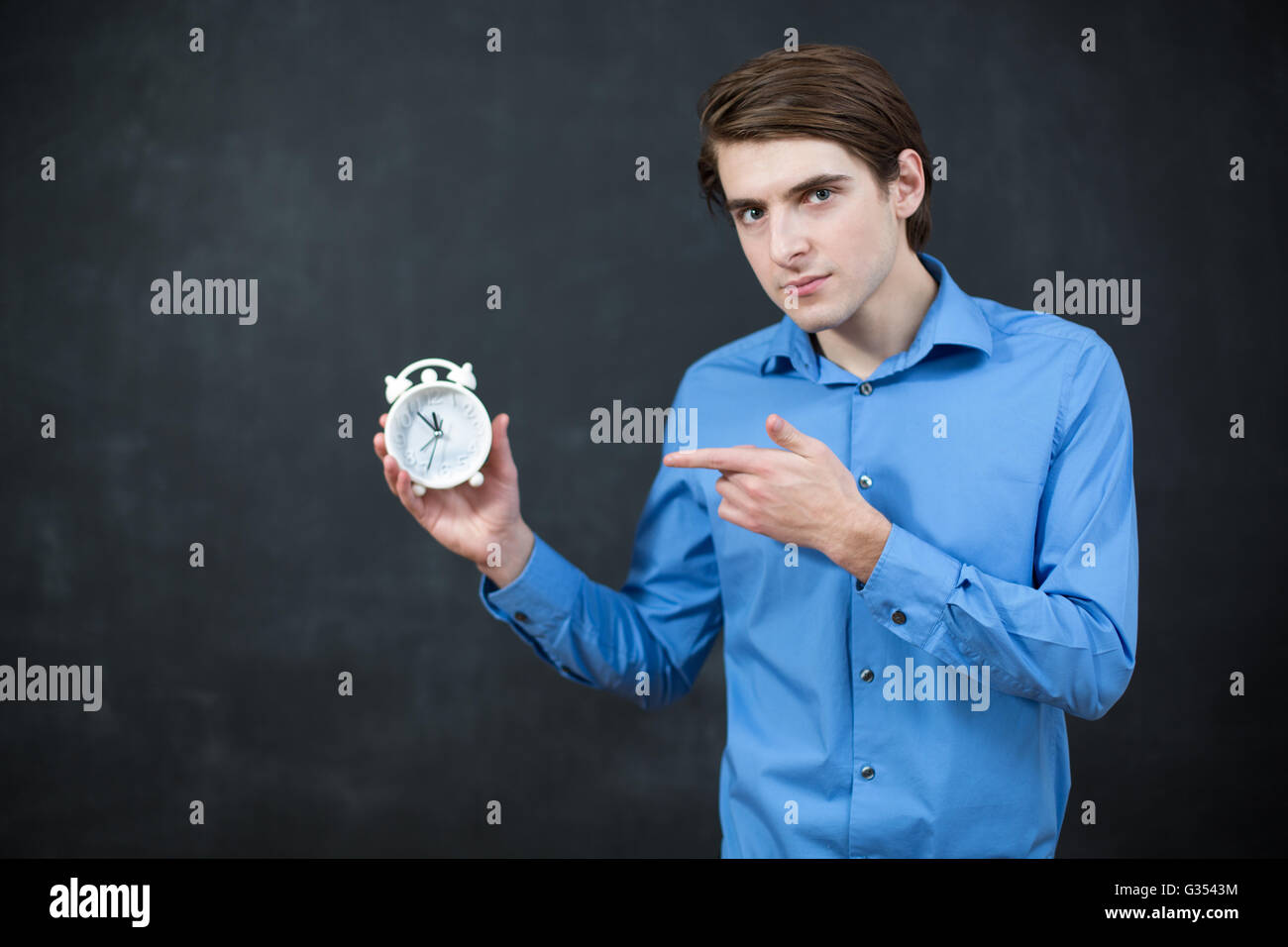 Successful businessman in formal wear pointing at clock Stock Photo - Alamy