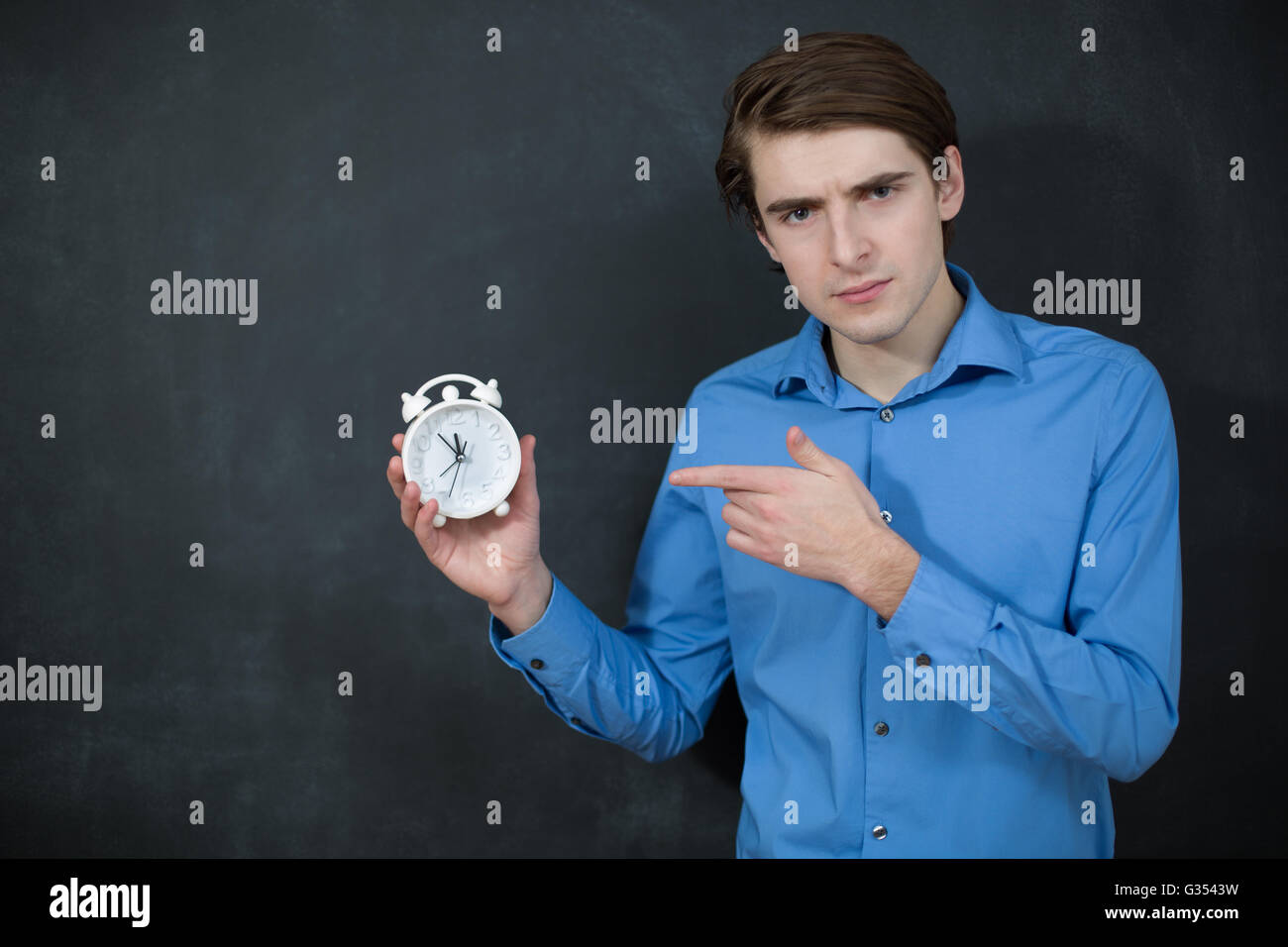Successful businessman in formal wear pointing at clock Stock Photo - Alamy