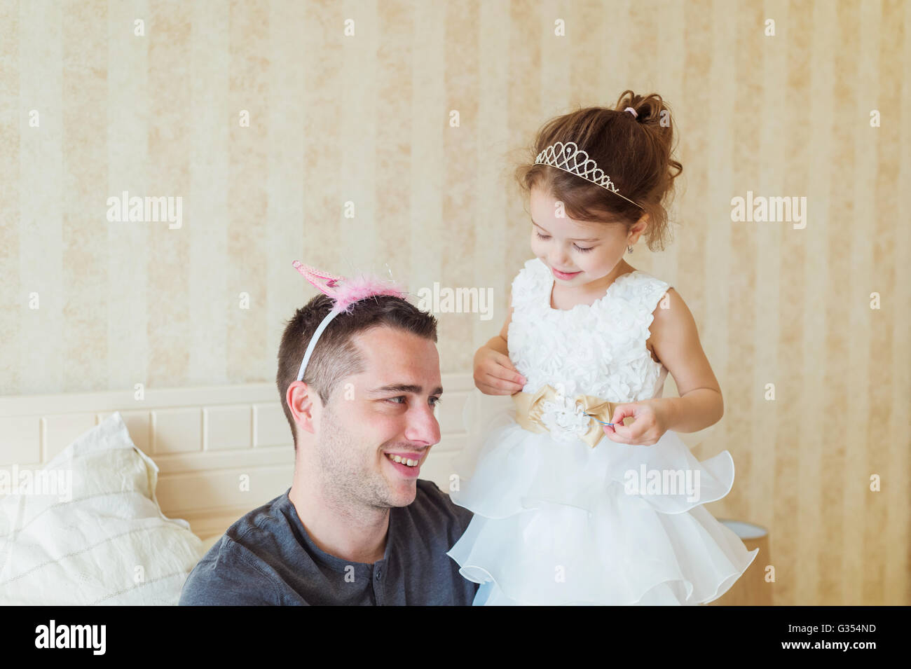 Cute girl putting a crown on her father head Stock Photo - Alamy