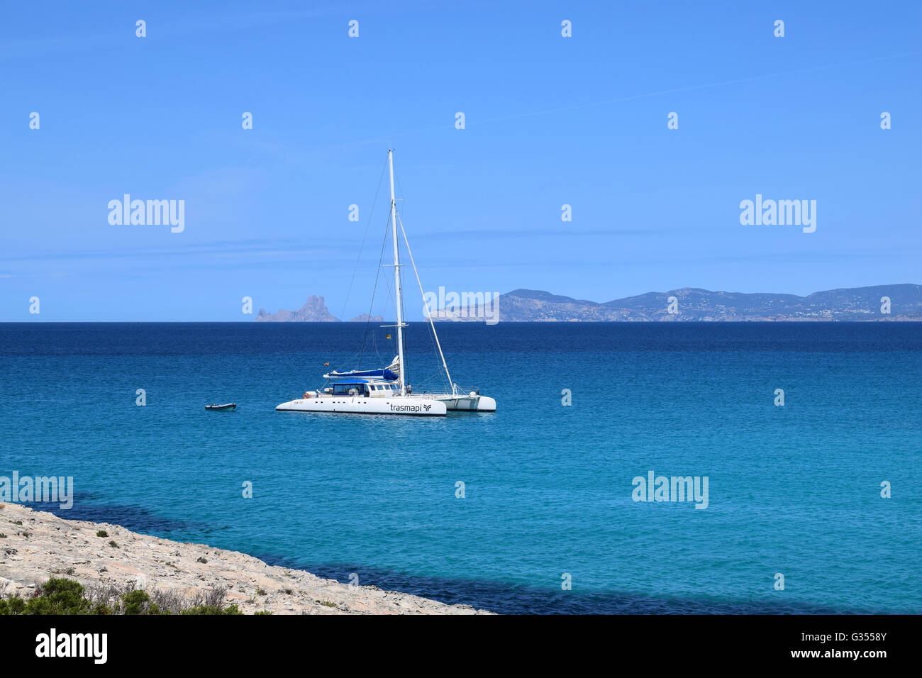 Trasmapi catamaran moored of the shores of Formentera with Ibiza in the ...