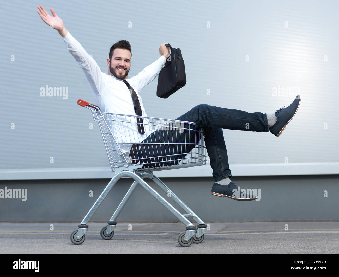 businessman driving in the shopping cart, consumerism Stock Photo - Alamy