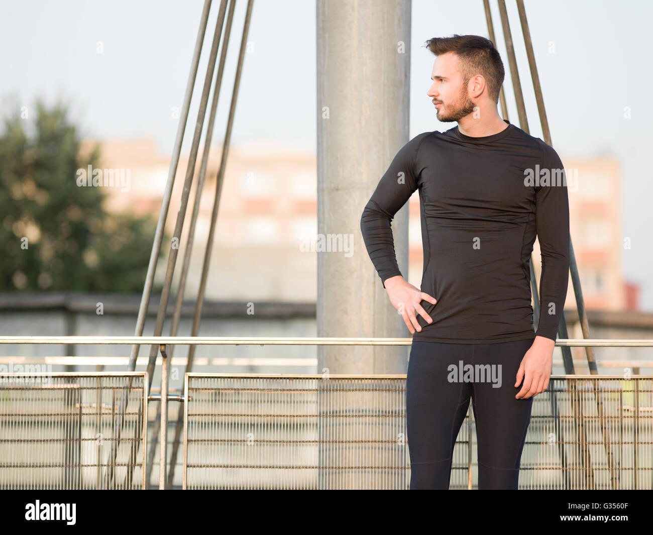 Young male runner taking a break on urban bridge Stock Photo - Alamy